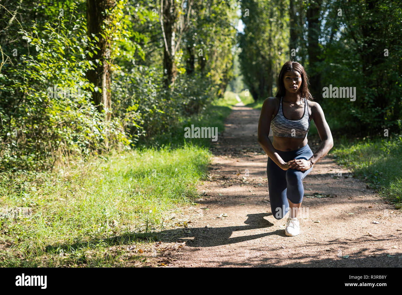 Female athlete warming up for workout in nature Stock Photo - Alamy