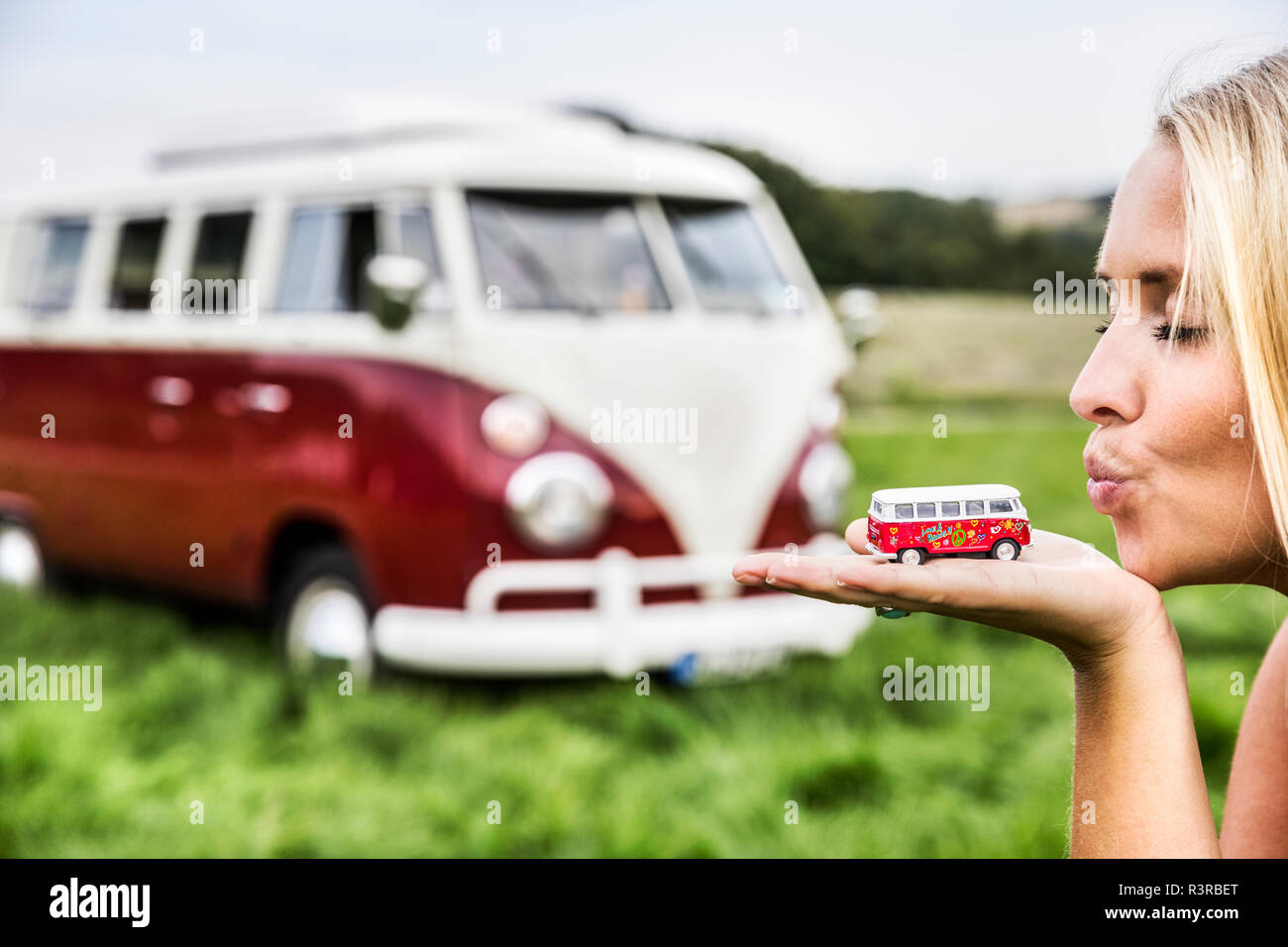 Woman kissing van model next to van in rural landscape Stock Photo - Alamy
