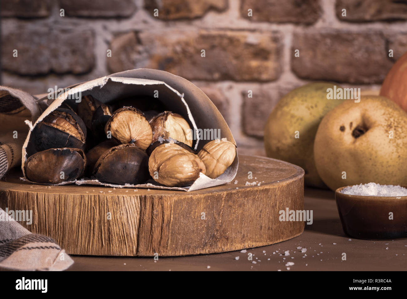 Roasted chestnuts in a paper cone, on a rustic kitchen countertop Stock ...