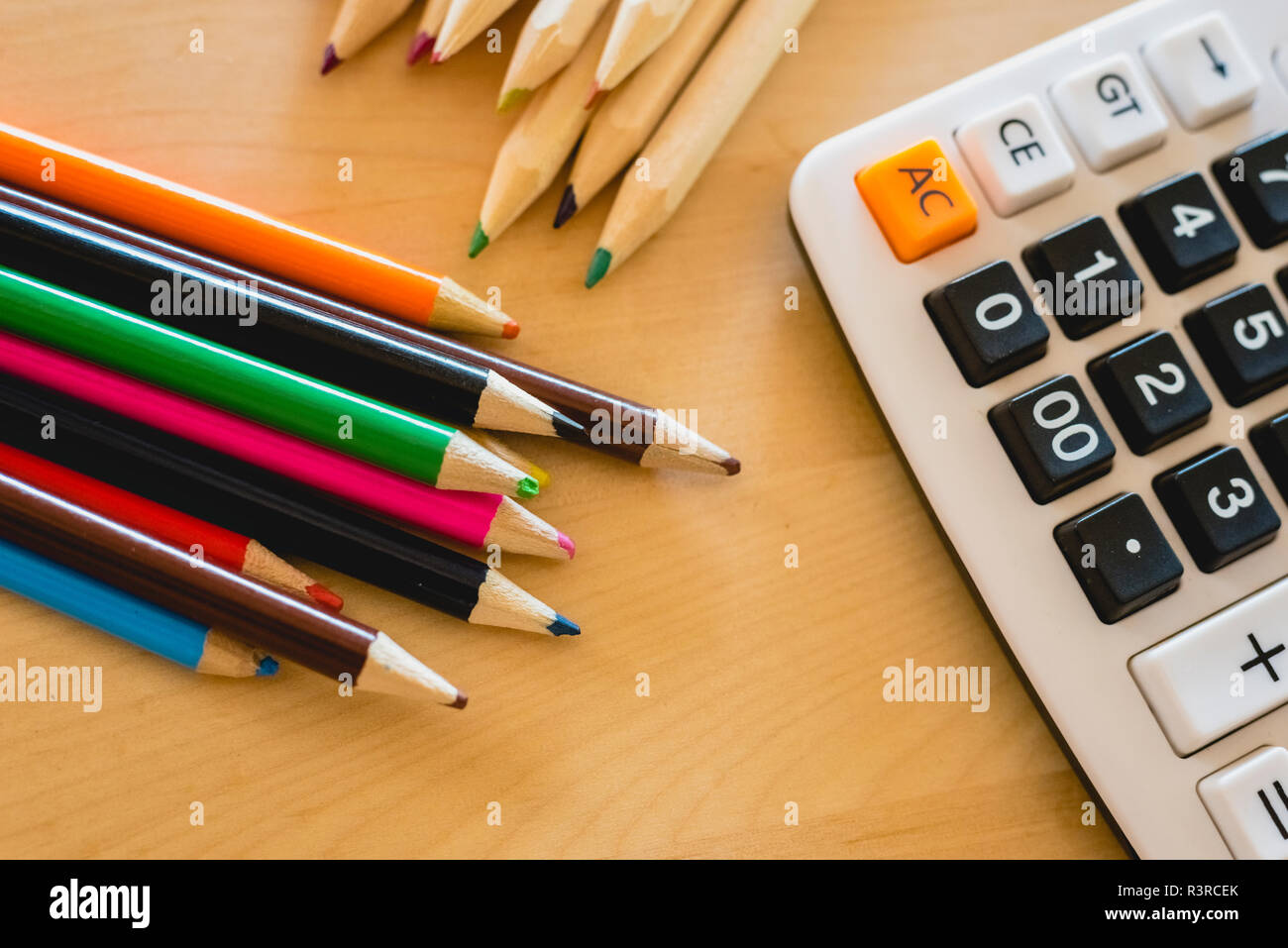 Colored pencils and calculator on a table Stock Photo - Alamy