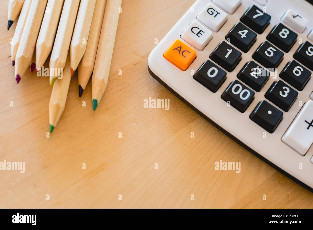 Colored pencils and calculator on a table Stock Photo - Alamy