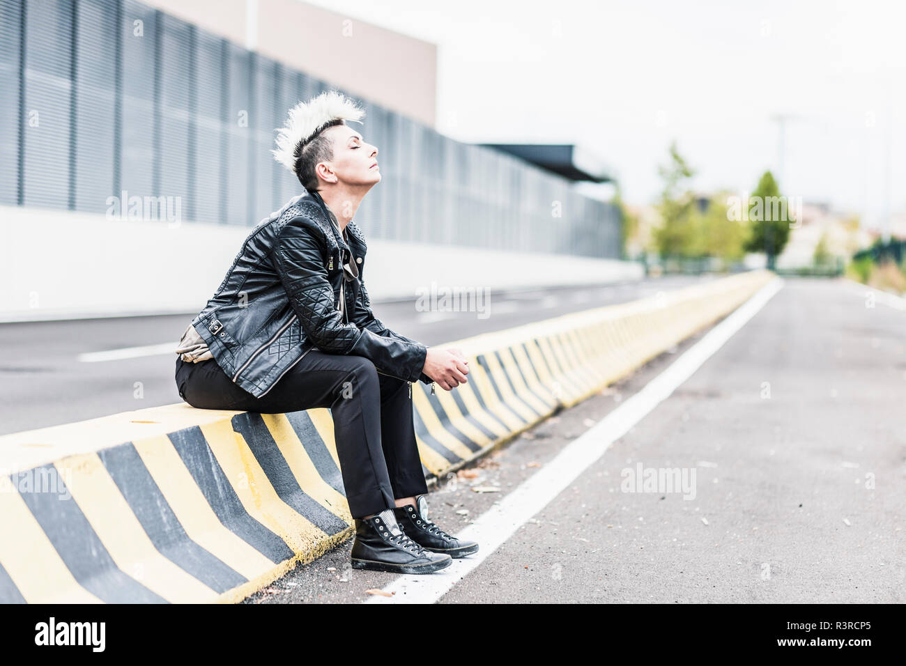 Punk woman sitting at the roadside with closed eyes Stock Photo - Alamy