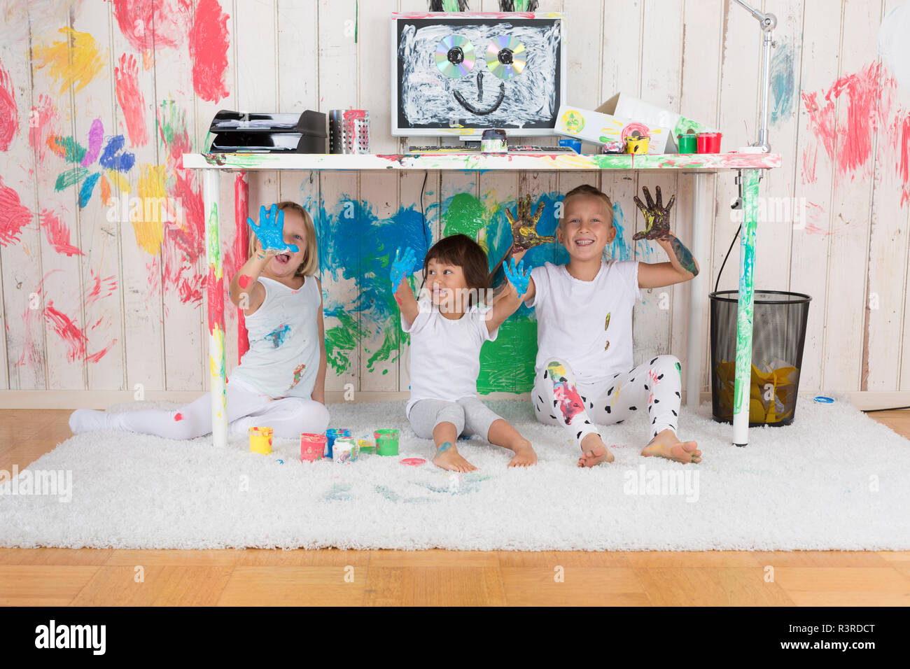 Three girls painting office with finger paint Stock Photo - Alamy