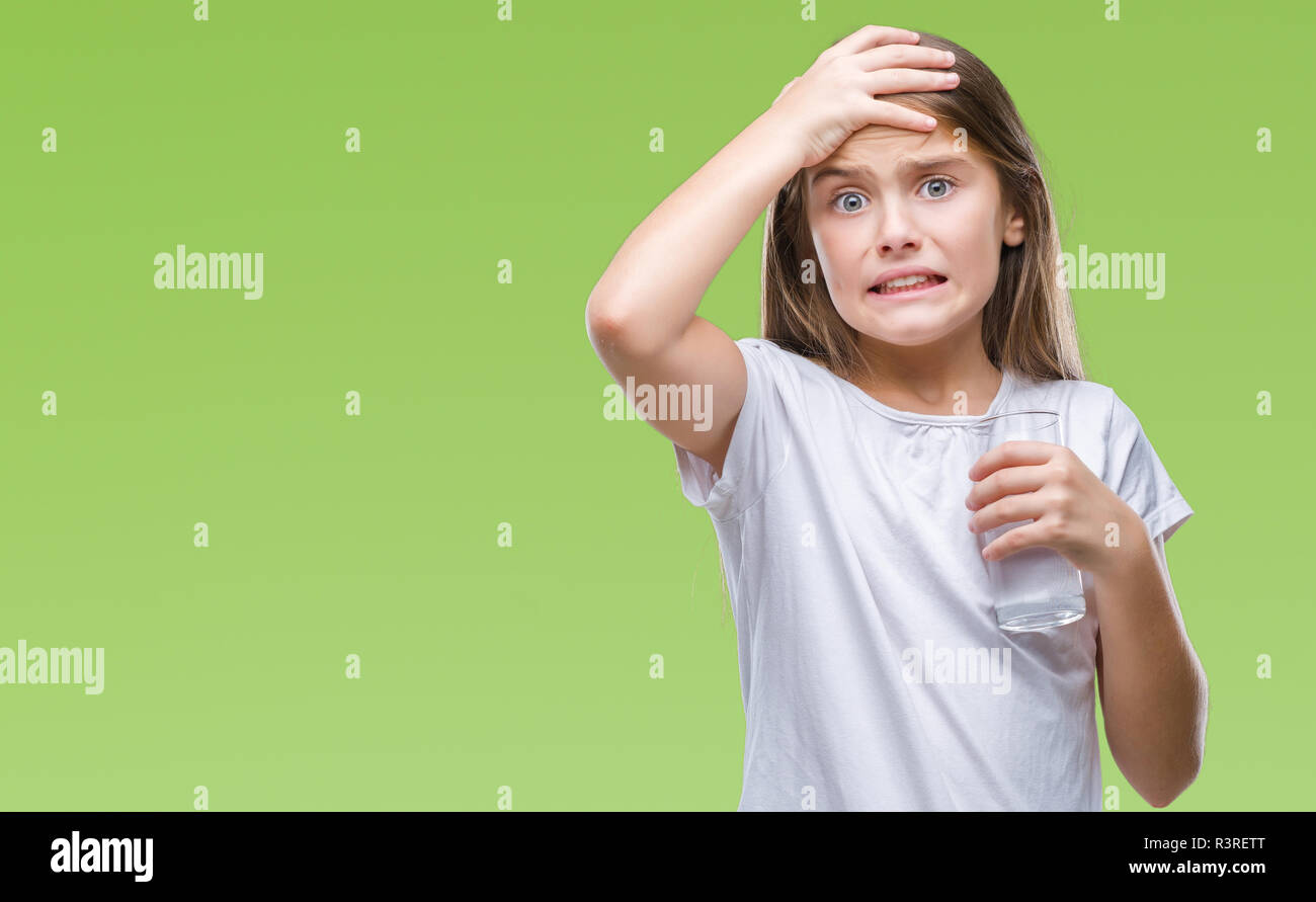 Young beautiful girl drinking glass of water over isolated background ...
