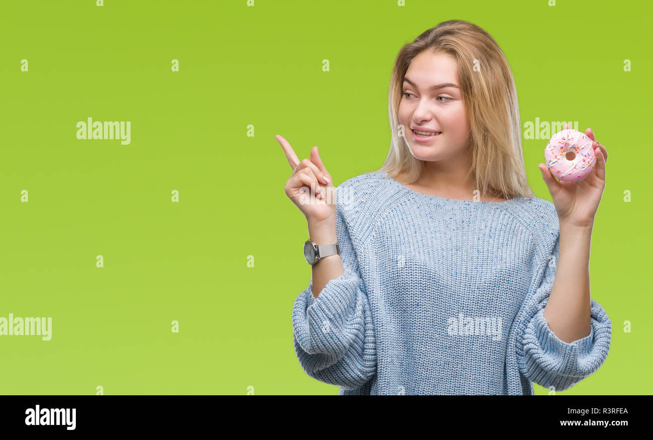 Young caucasian woman eating sweet donut over isolated background very ...