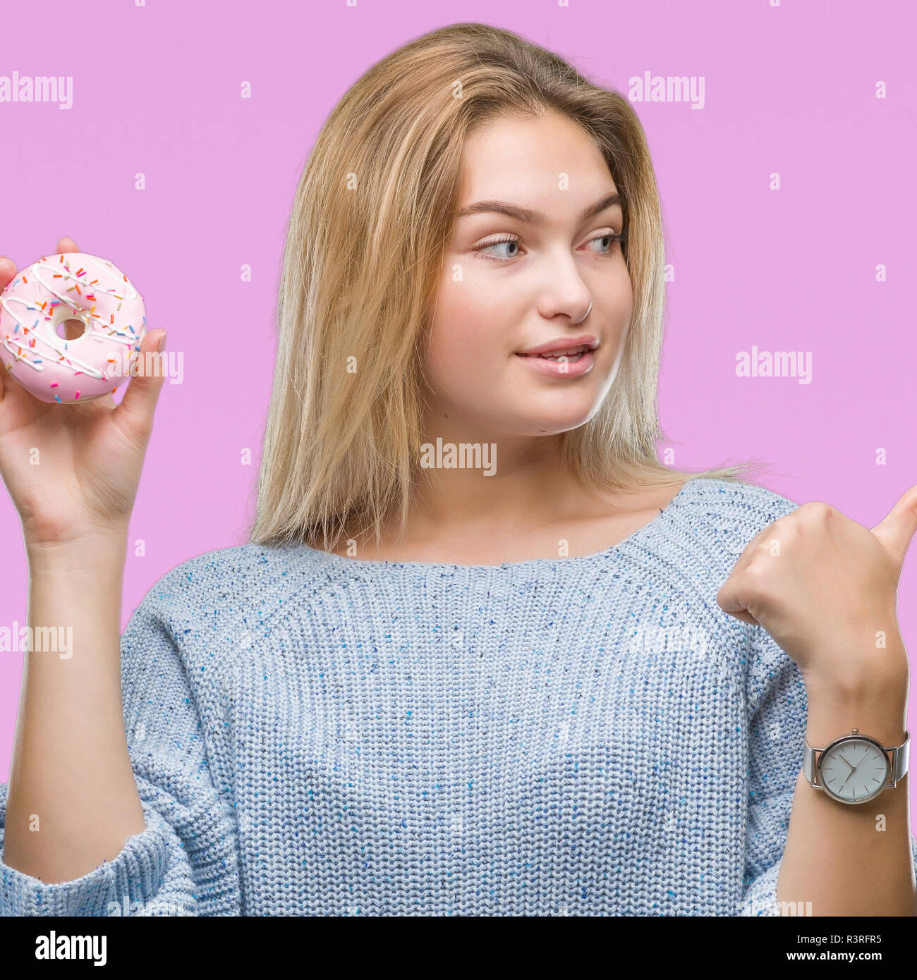 Young caucasian woman eating sweet donut over isolated background ...