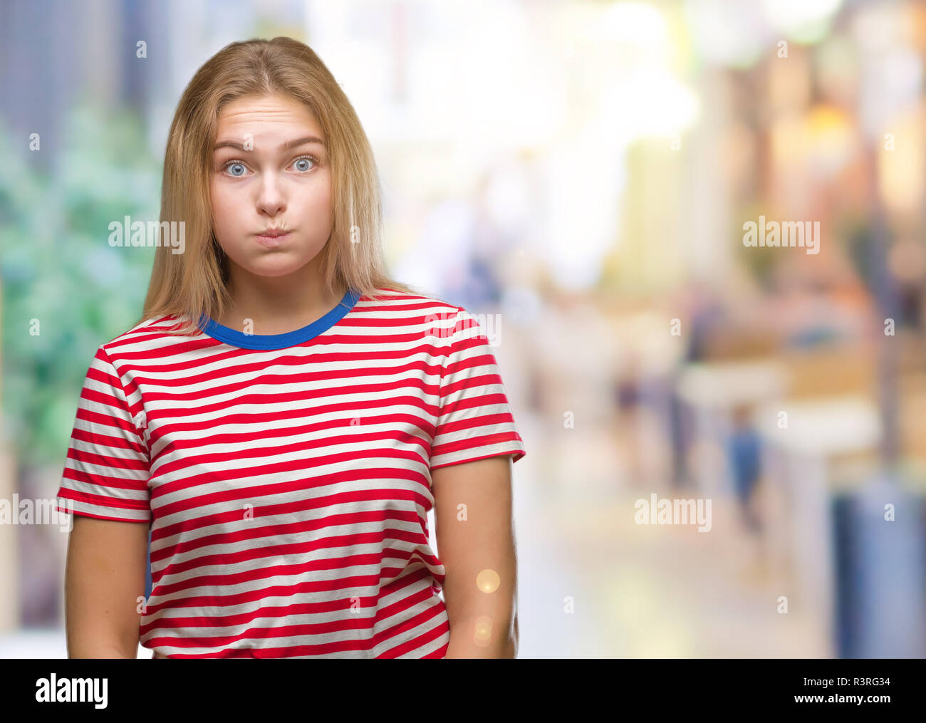 Young caucasian woman over isolated background puffing cheeks with ...
