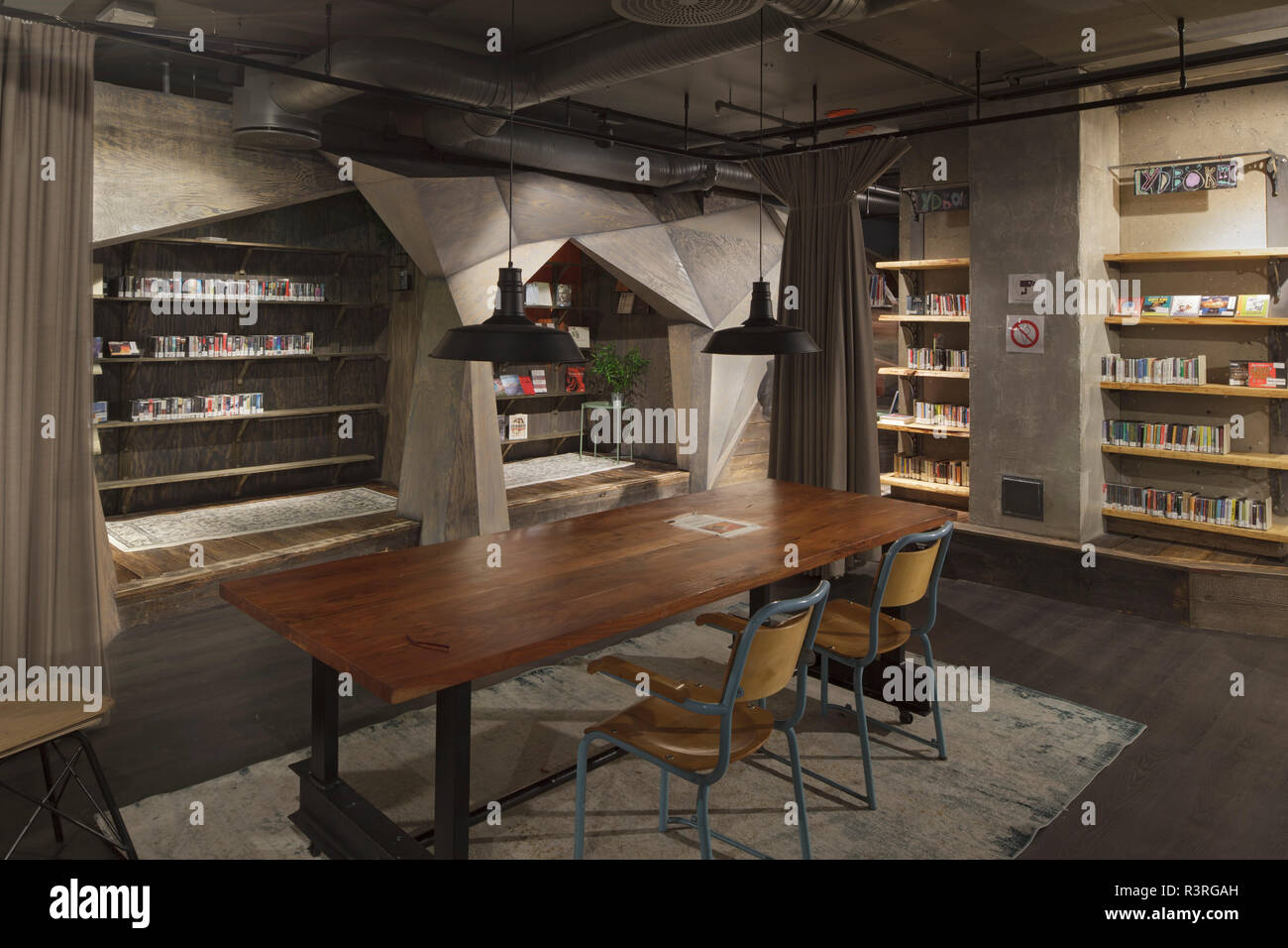Timber table with bookshelves and geometric surround. Deichman Library ...
