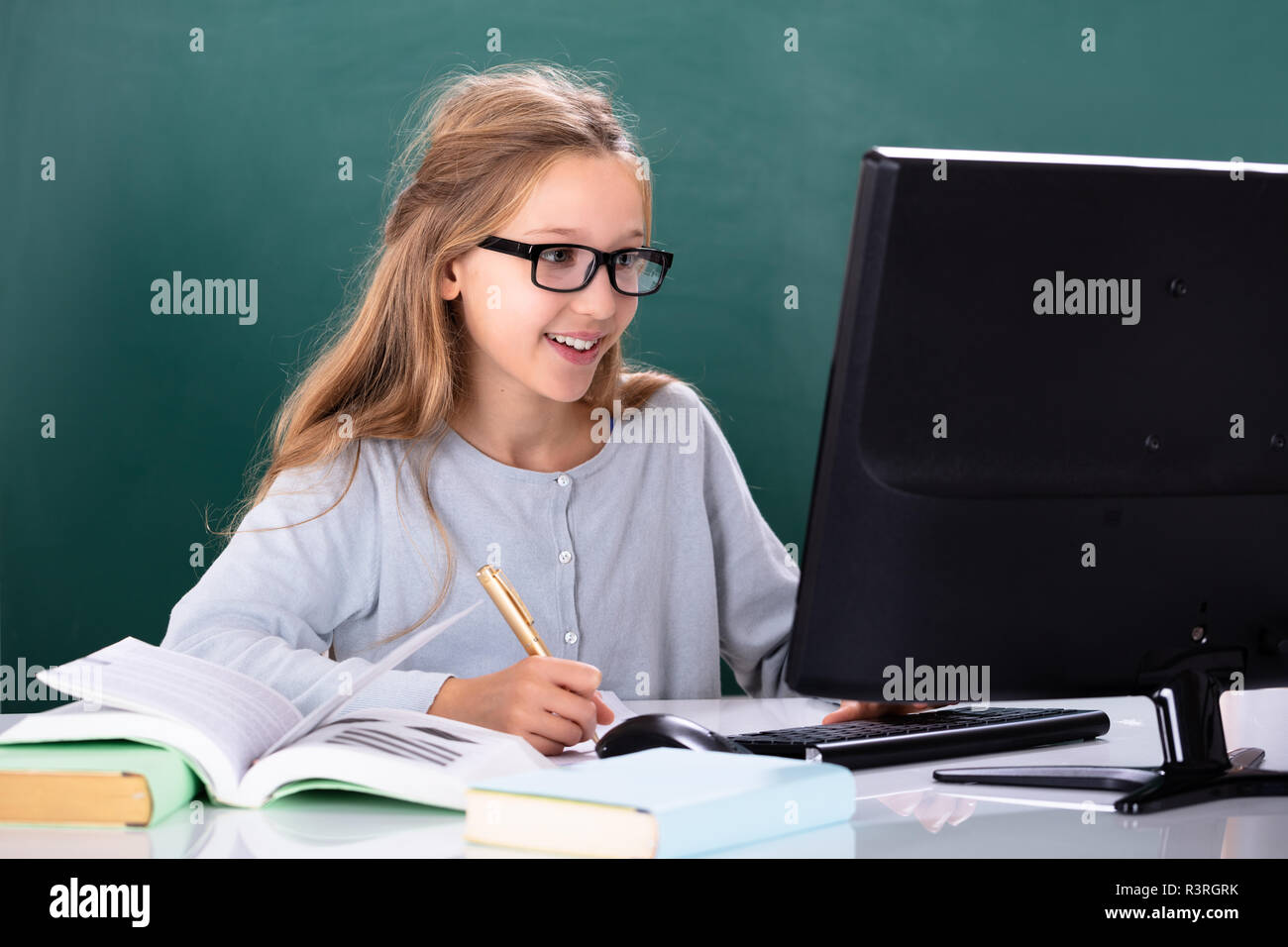 Happy Girl Using Computer While Studying In Classroom Stock Photo - Alamy