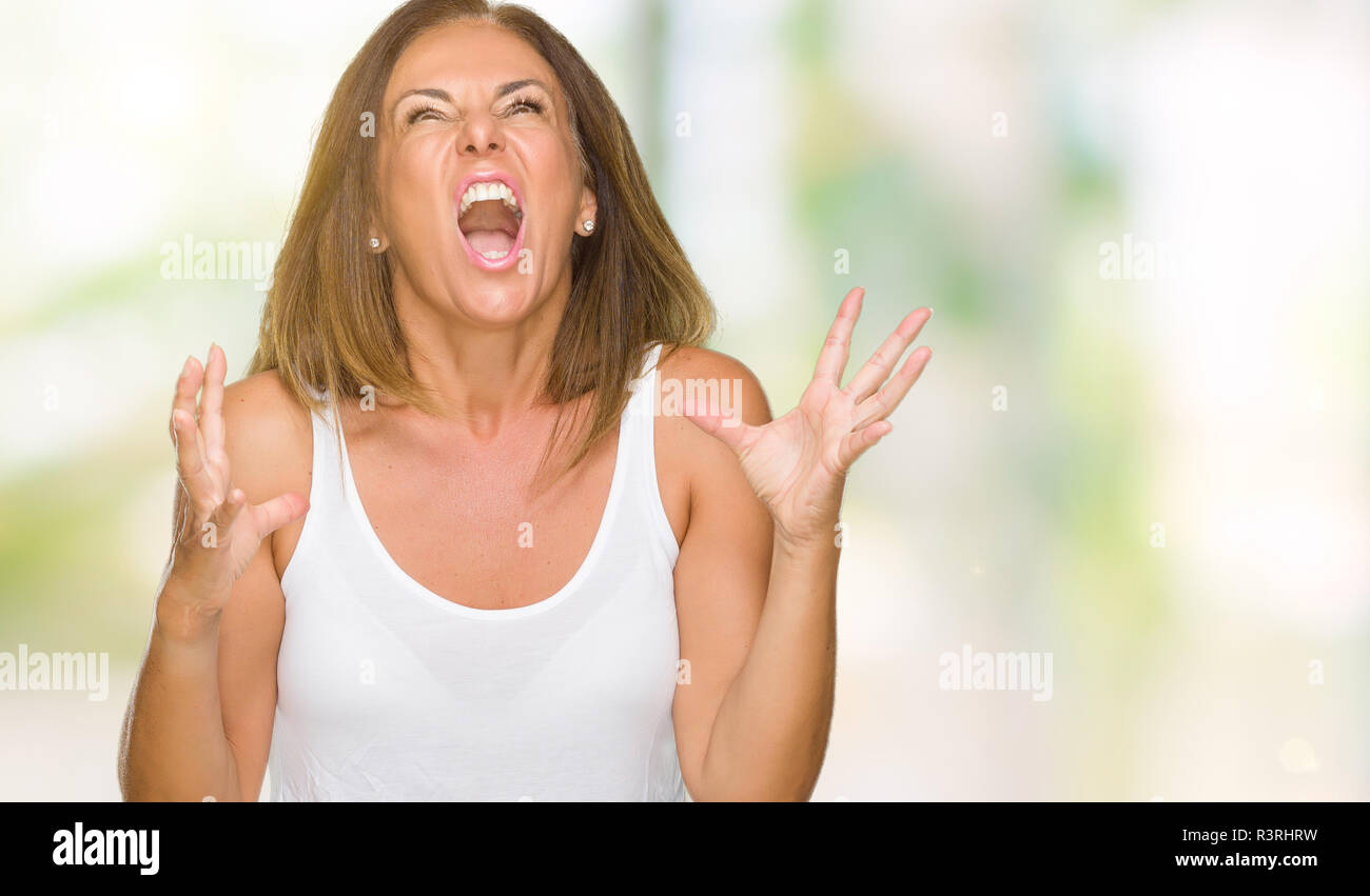 Beautiful middle age casual adult woman over isolated background crazy ...