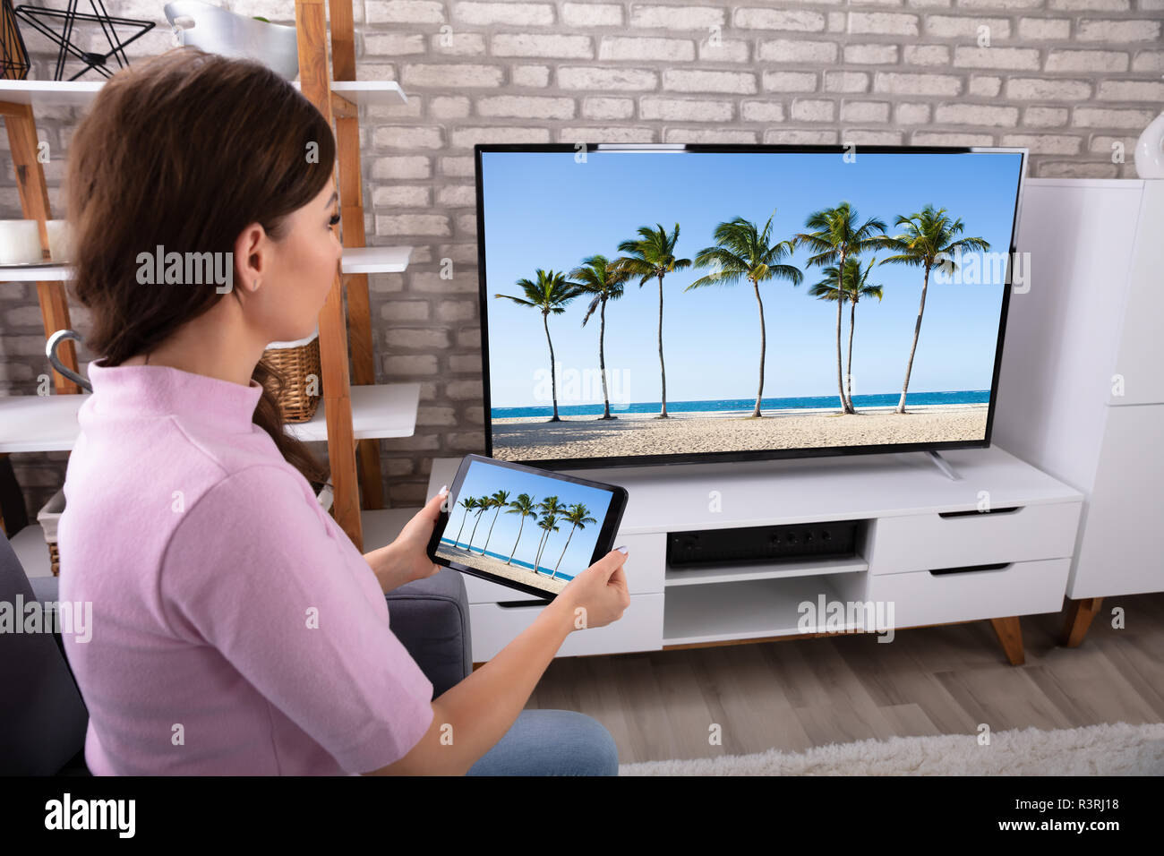Side View Of A Young Woman Connecting Television Channel Through ...