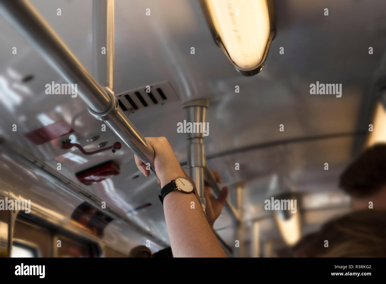 hand holding onto the bar in an old subway during rush hour, selected ...