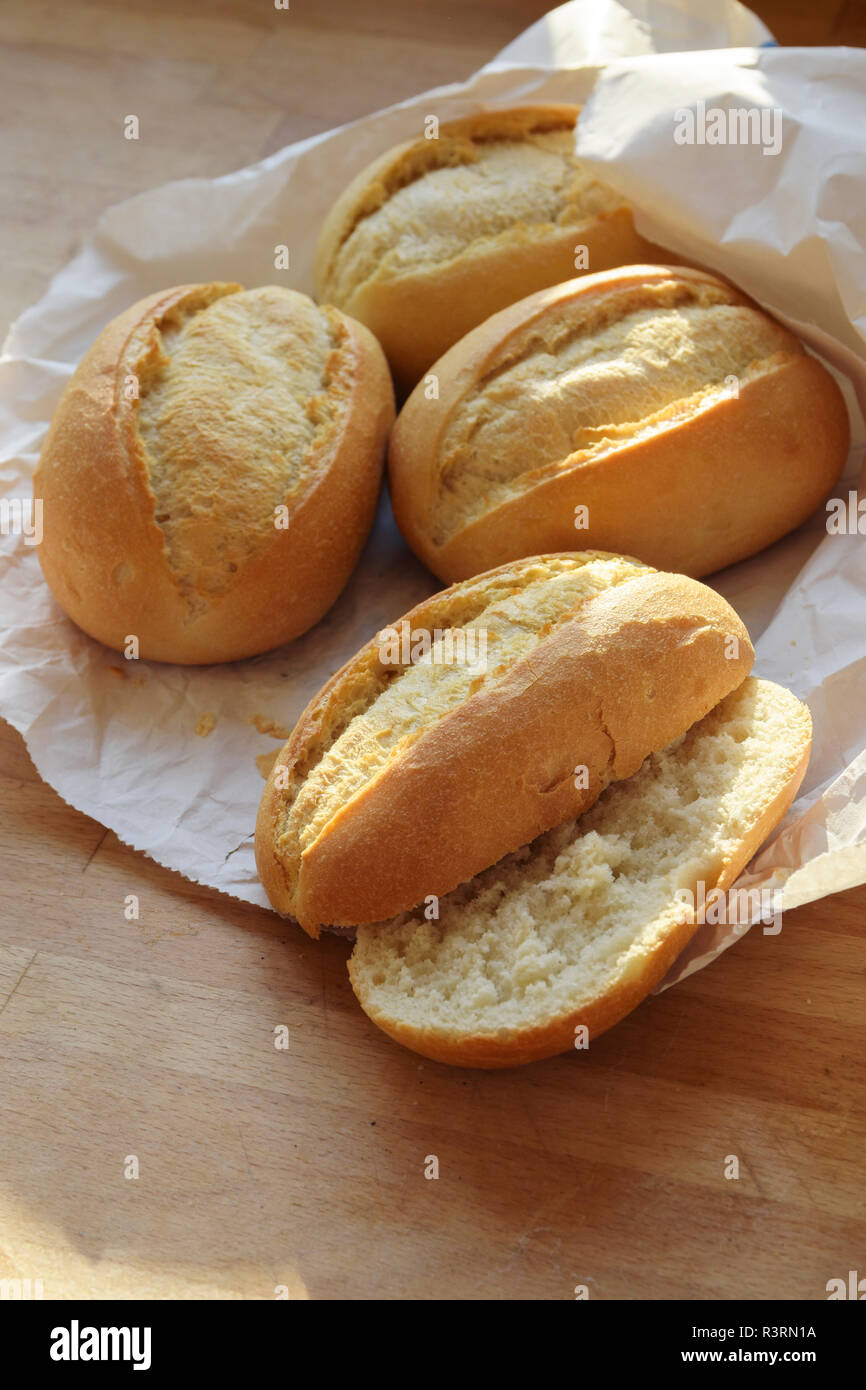 bread rolls or buns whole and halved fresh from the bakery in a white ...