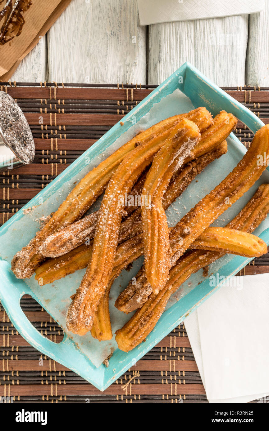 Traditional churros with hot chocolate dipping sauce on wooden counter ...