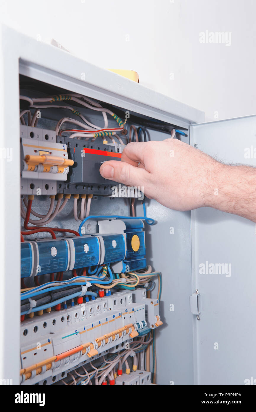 The man turns on the electric switch. Checking electrical equipment in ...