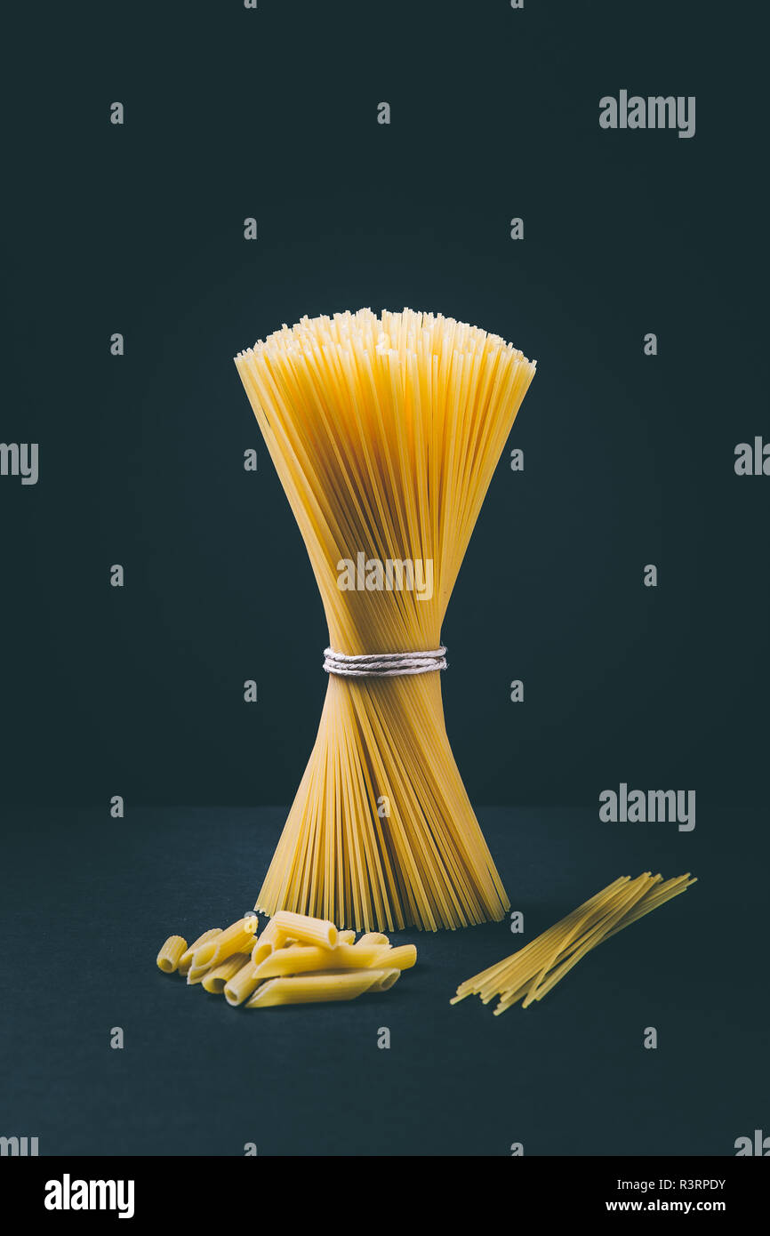 spaghetti in bunch on black background Stock Photo - Alamy