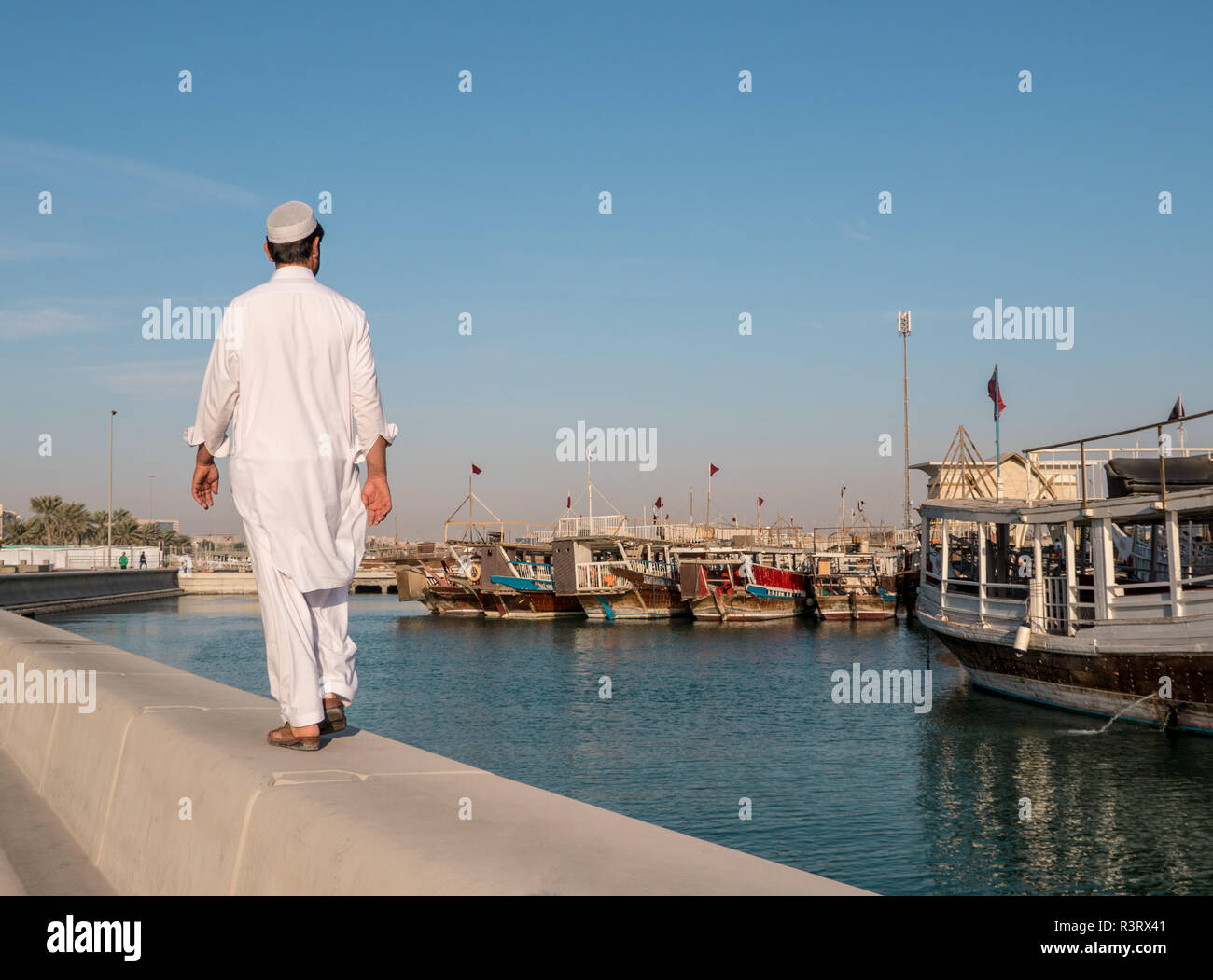 Middle eastern Man Walking by Corniche road in Doha. View with ...