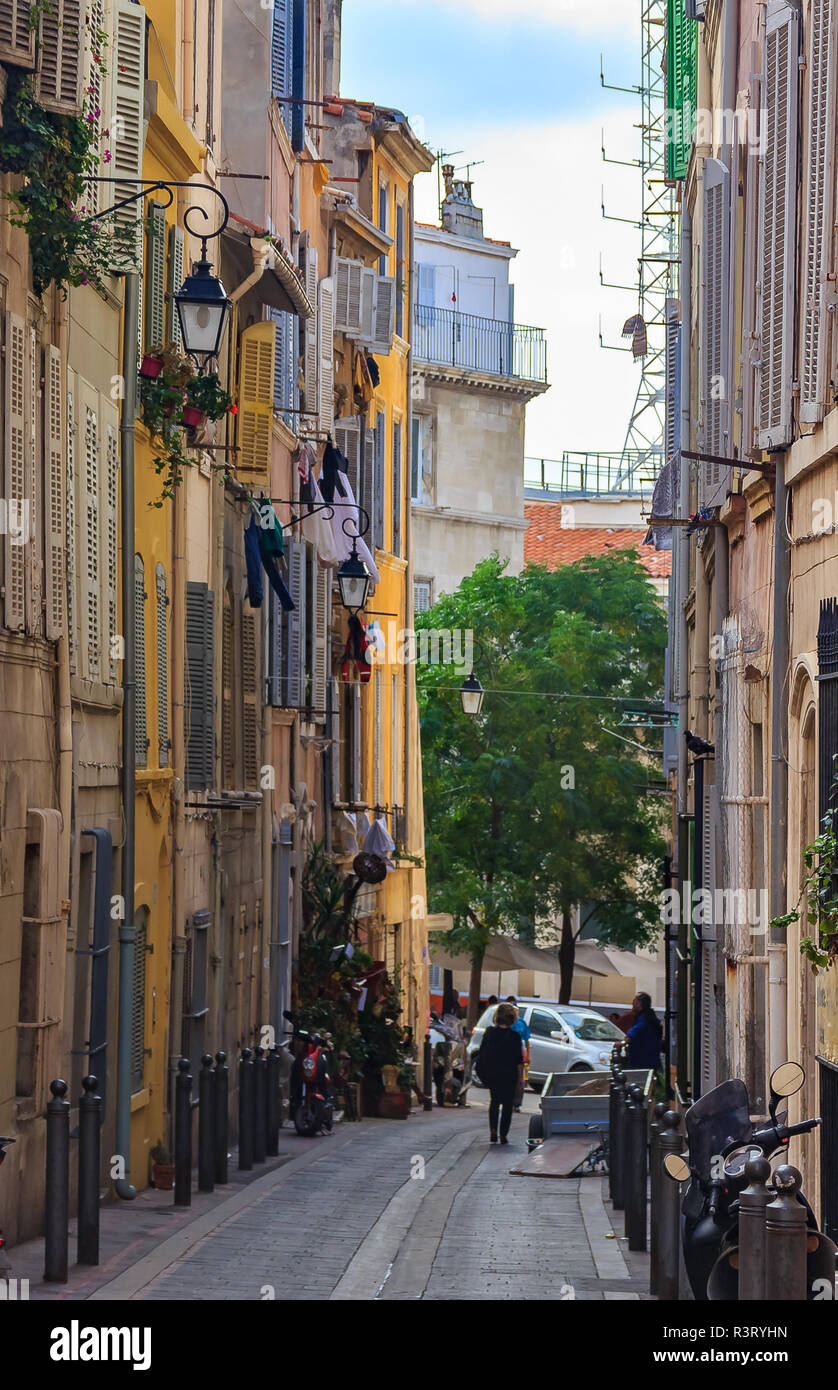 Marseille, France - October 19, 2013: People walking between old houses ...