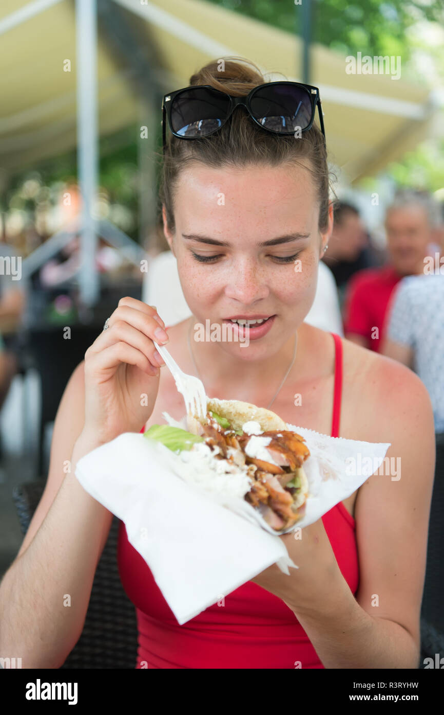 girl or Woman eating sandwich gyros. Girl with pleasure eats burger ...
