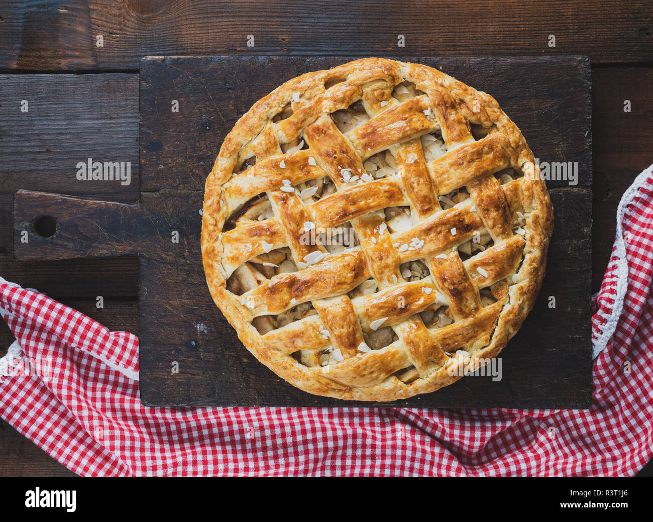 Baked whole round apple pie on a rectangular old brown board, wooden ...