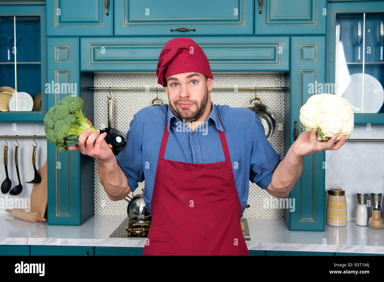 Guy chef with surprised face hold cauliflower and broccoli vegetable in ...
