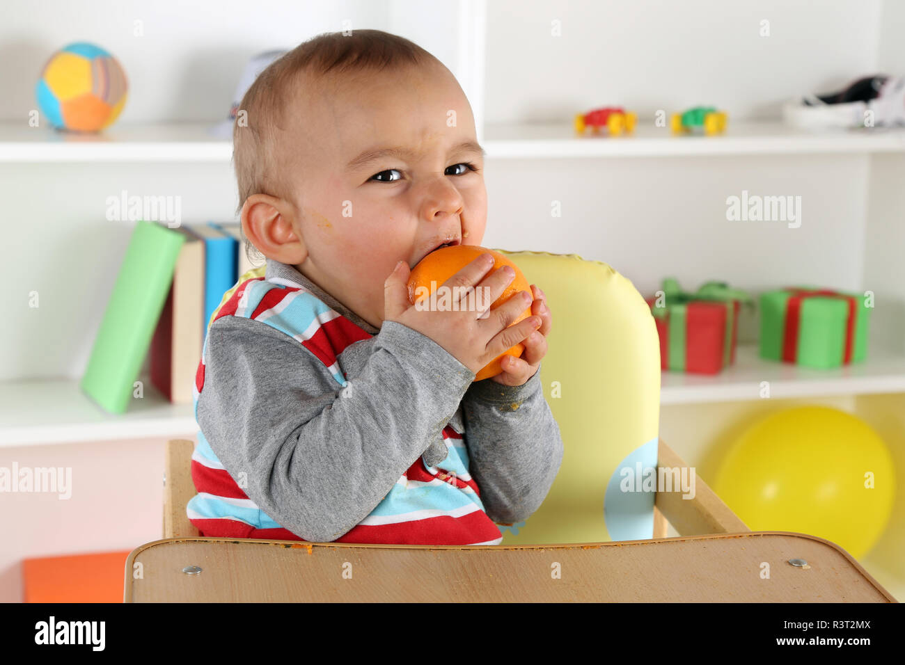 baby child eating an orange fruit Stock Photo - Alamy