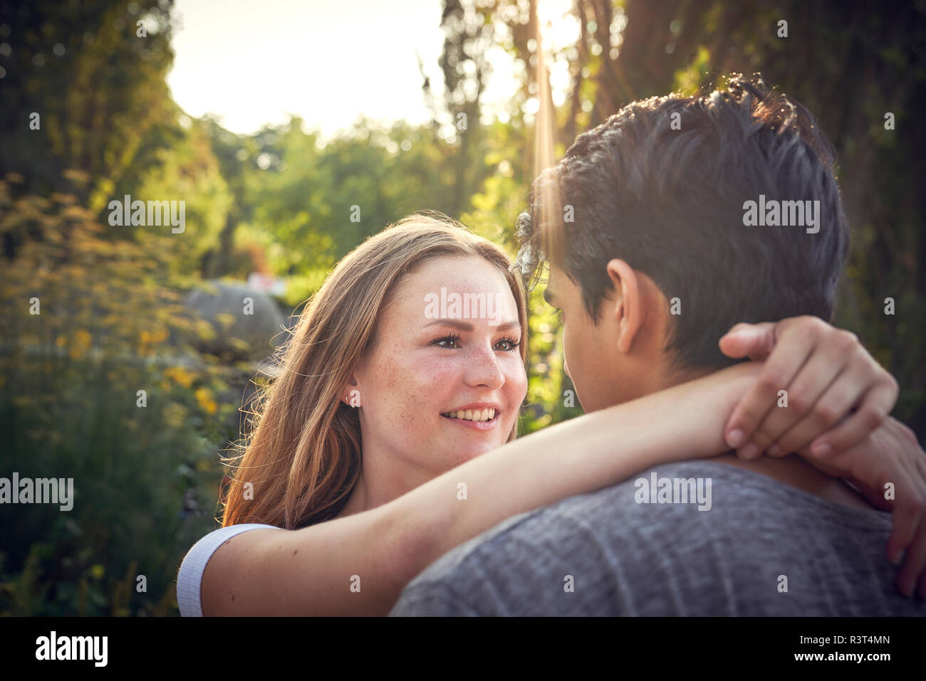 Happy young couple flirting in a park in summer Stock Photo - Alamy