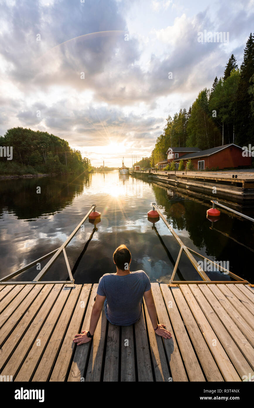 Man sitting on jetty rear view hi-res stock photography and images - Alamy