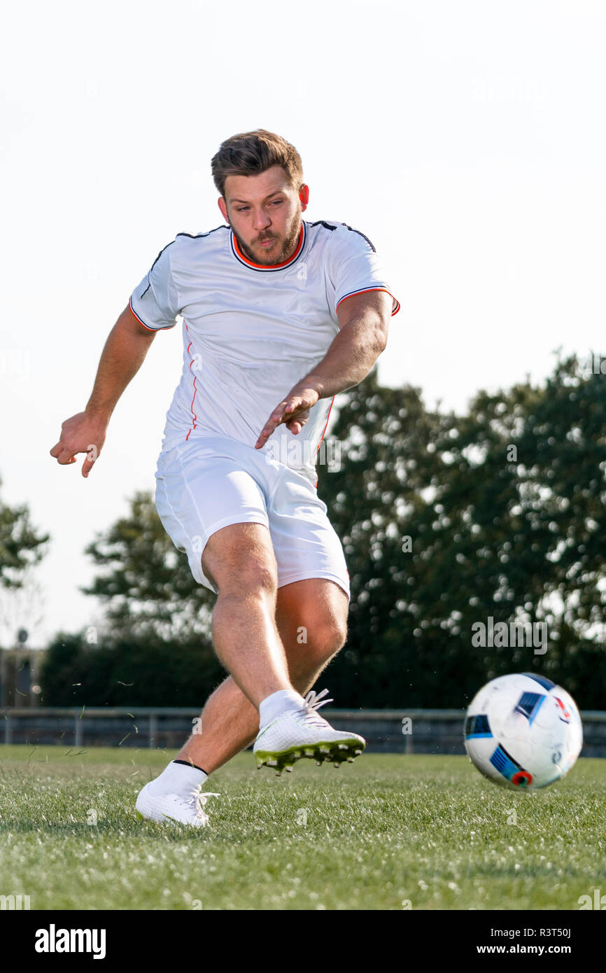 Man kicking ball hi-res stock photography and images - Alamy