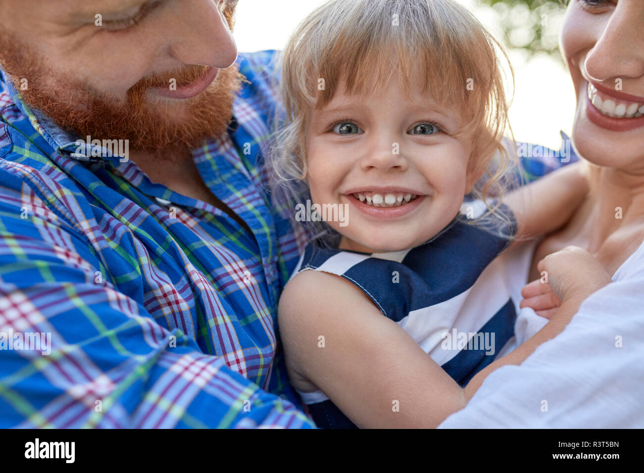Happy parents hugging her daughter outdoors Stock Photo - Alamy