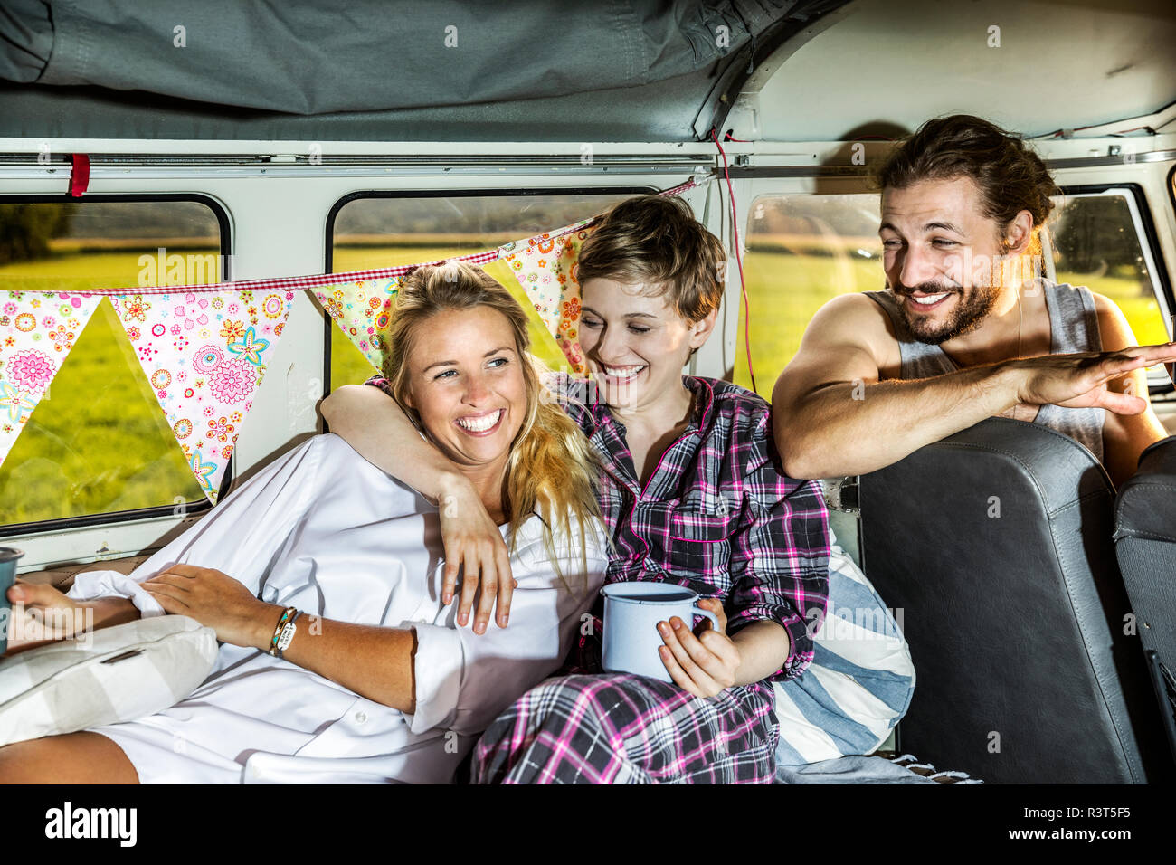 Happy friends inside a van enjoying coffee Stock Photo - Alamy