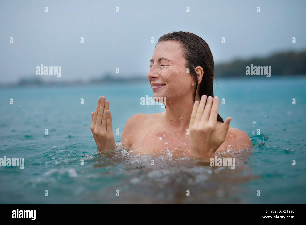 Portrait of young woman bathing in lake on rainy day Stock Photo - Alamy