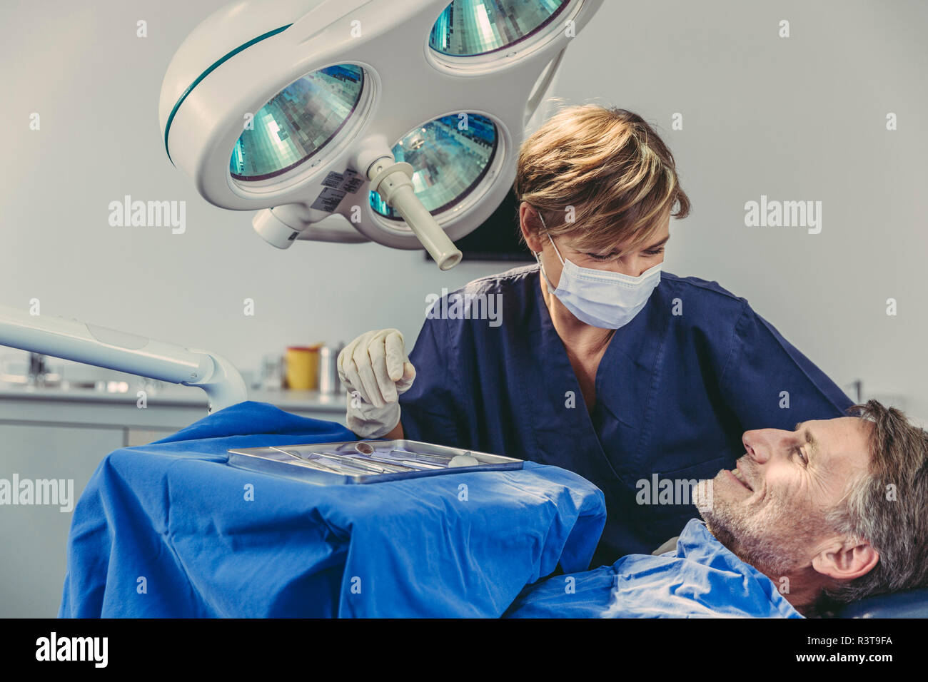 Patient smiling at dental surgeon after successful treatment Stock ...