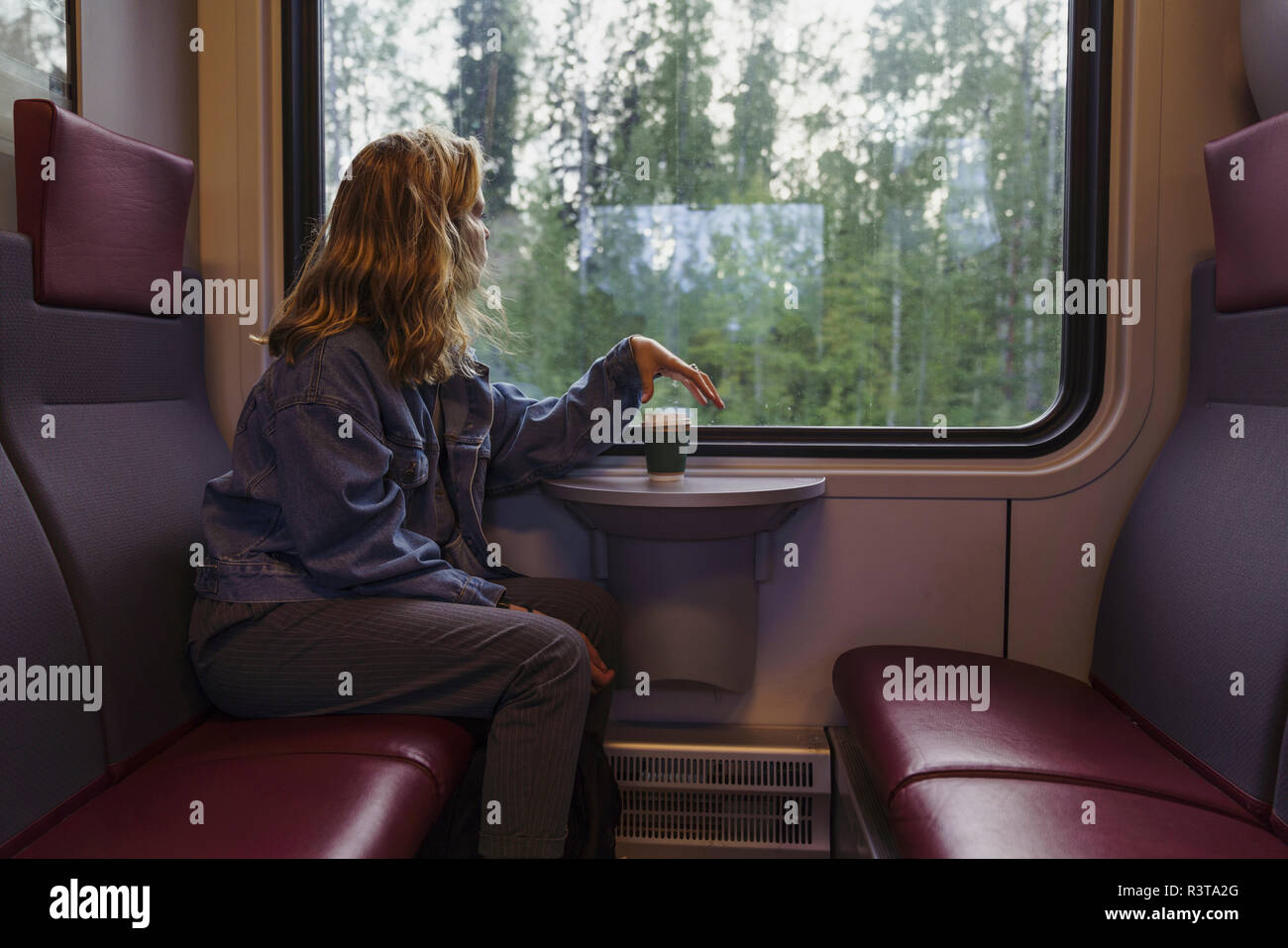 Woman traveling by train looking out of window Stock Photo - Alamy