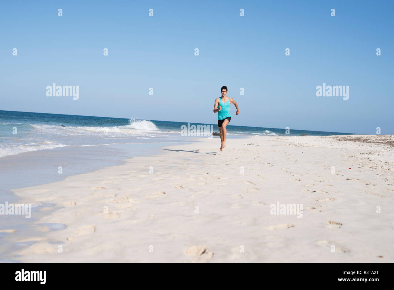 Spain, Canary Islands, Fuerteventura, young man running on the beach ...