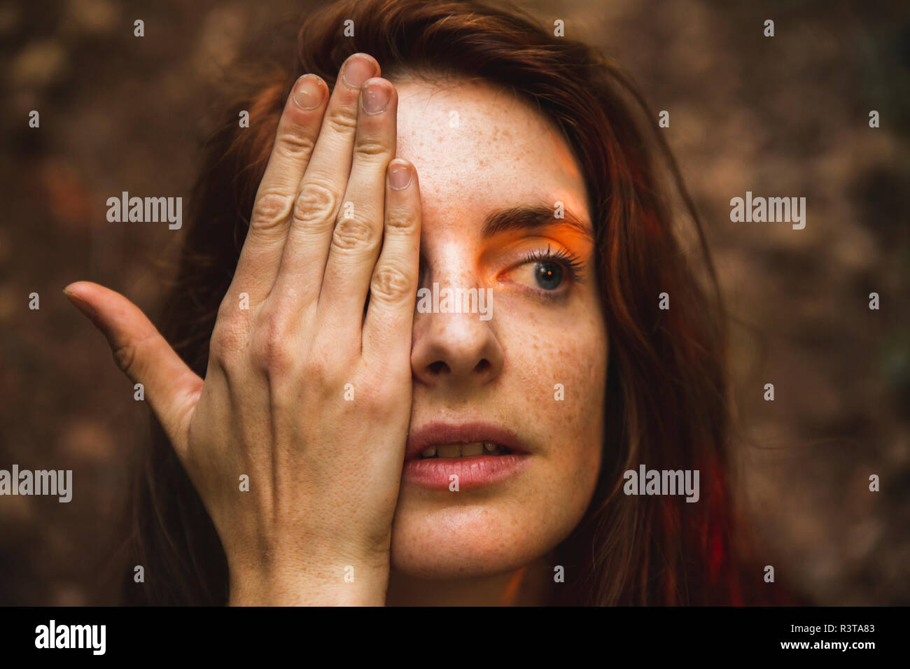 Portrait of young woman with freckles covering one eye Stock Photo - Alamy