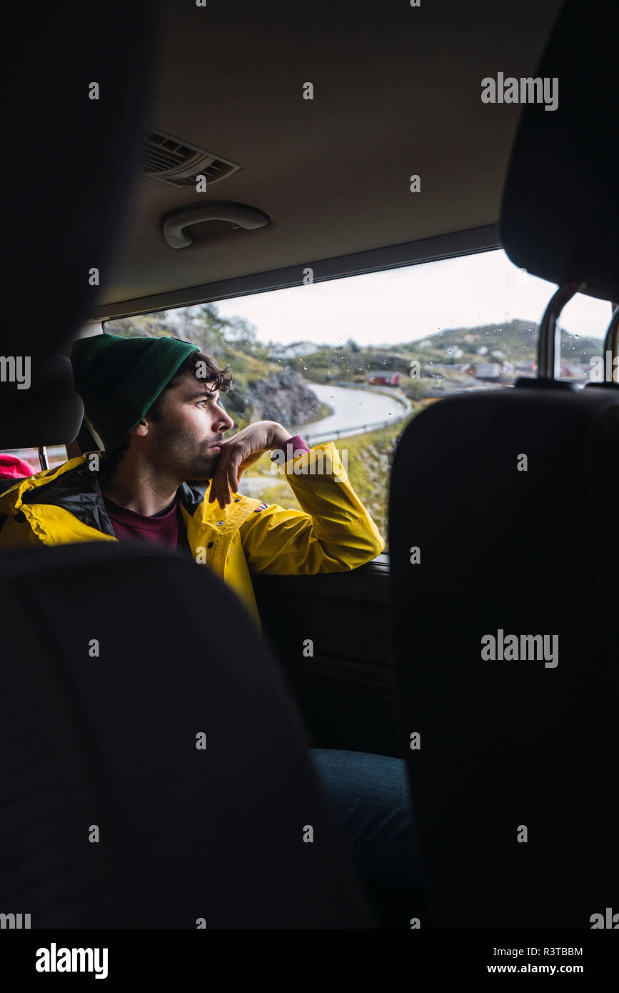 Norway, Lofoten, young man in a car looking out of window Stock Photo ...