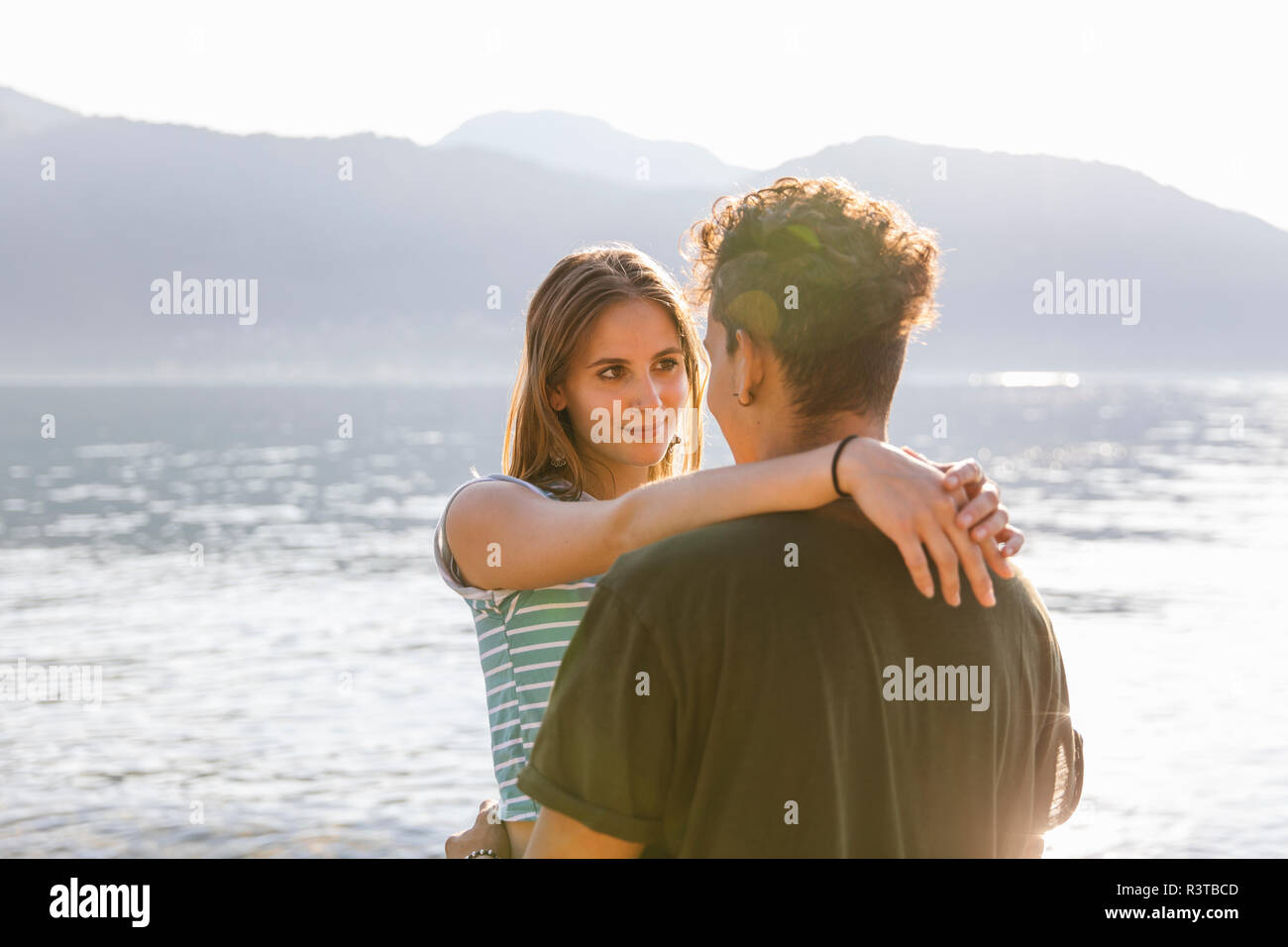 Affectionate young woman embracing boyfriend at the lakeside Stock ...