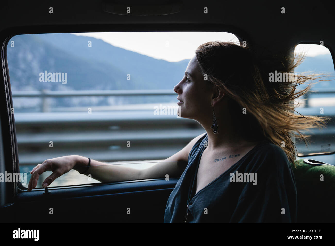 Young woman sitting on backseat in a car looking out of window Stock ...