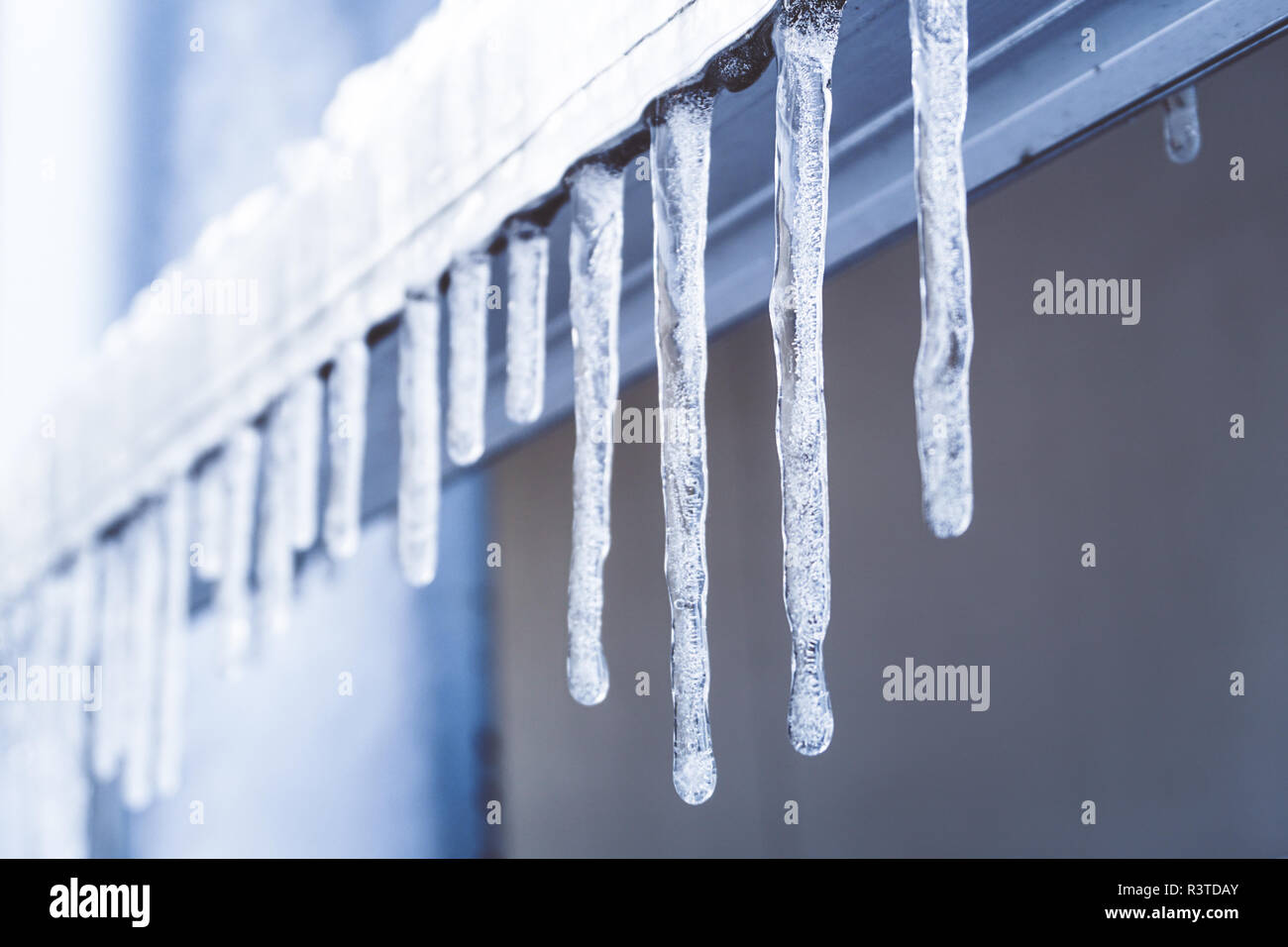 Icicle melt is hanging from a roof Stock Photo - Alamy