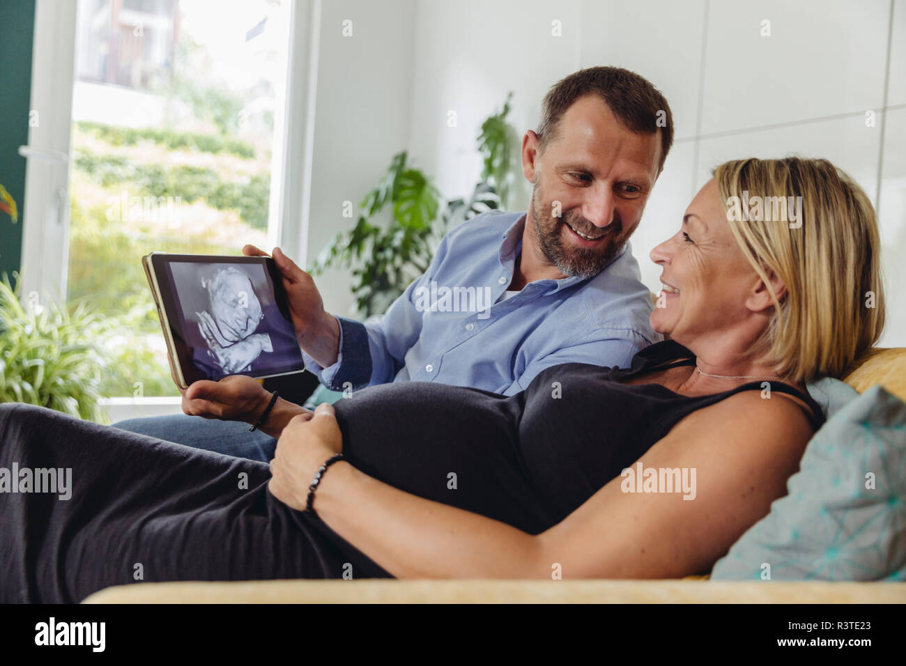 Mature pregnant couple watching a 3D image of their unborn child on ...
