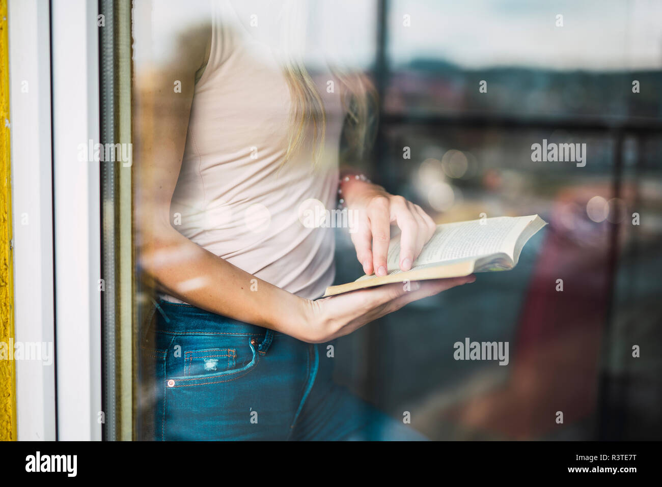 Young woman reading book behind hi-res stock photography and images - Alamy