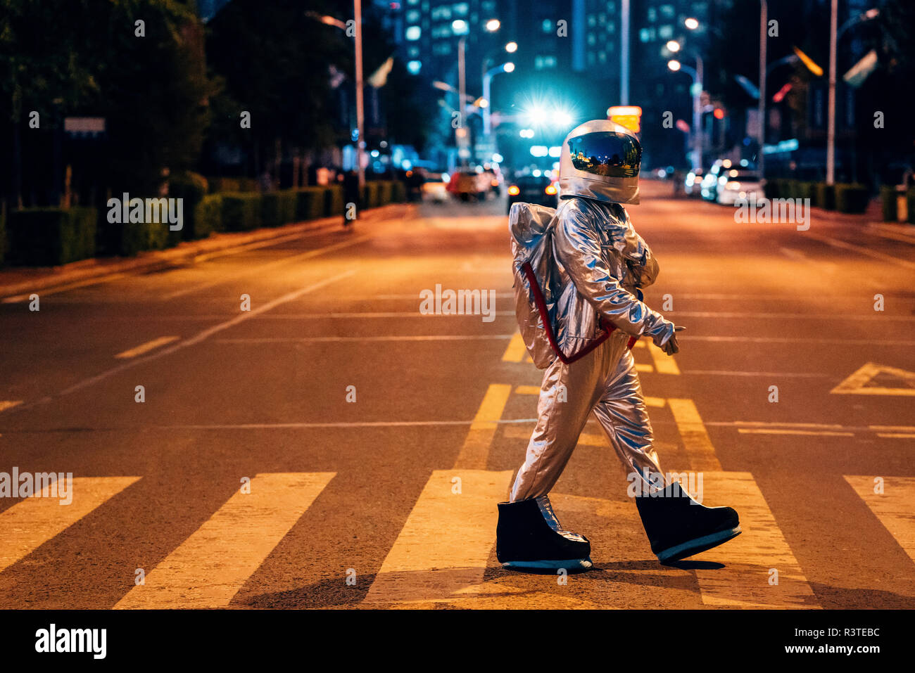 Spaceman walking on a street in the city at night Stock Photo - Alamy