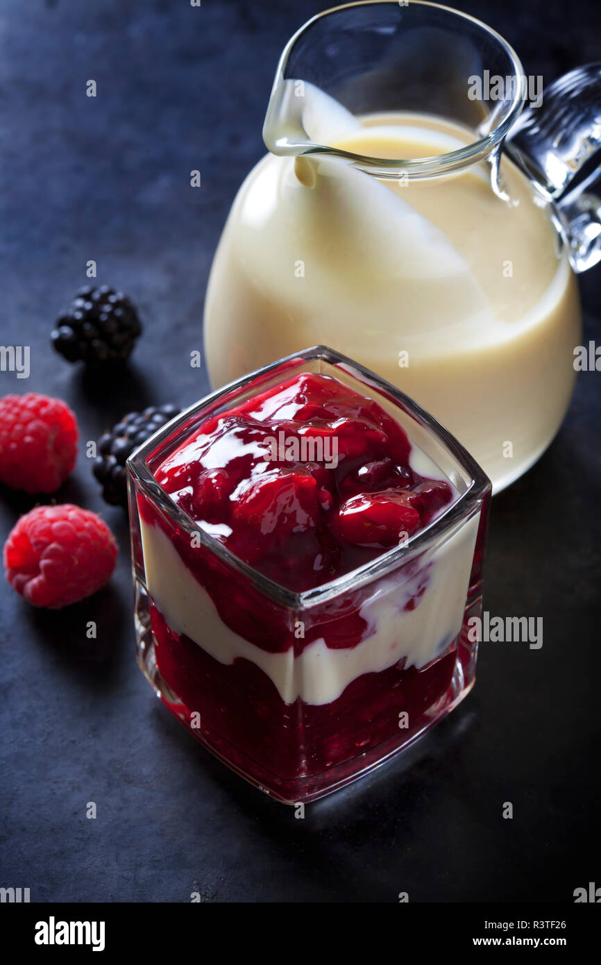 Red fruit compote with vanilla sauce layered in a glass Stock Photo - Alamy