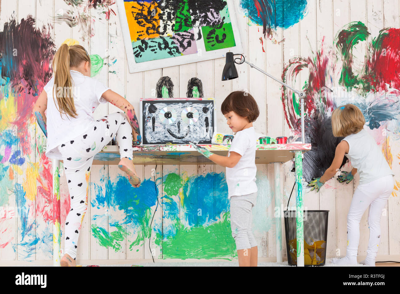 Three girls painting office with finger paint Stock Photo - Alamy