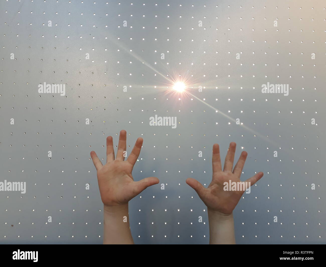 Child's hands with ray of light through bored panel Stock Photo - Alamy