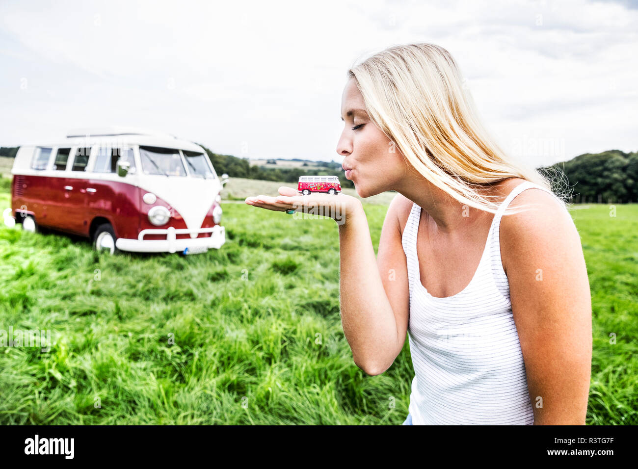 Woman kissing van model next to van in rural landscape Stock Photo - Alamy