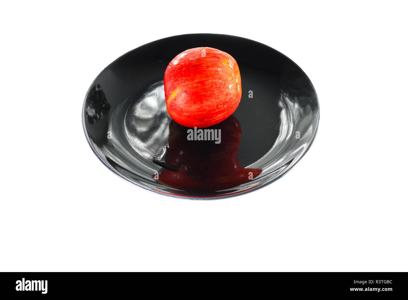red apple and water drip in black plate on white background Stock Photo ...