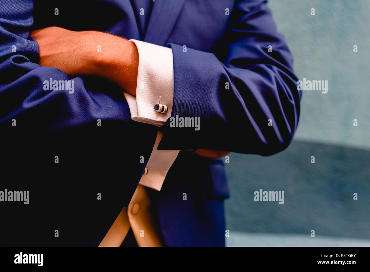 Crossed arms of businessman with blue suit Stock Photo - Alamy