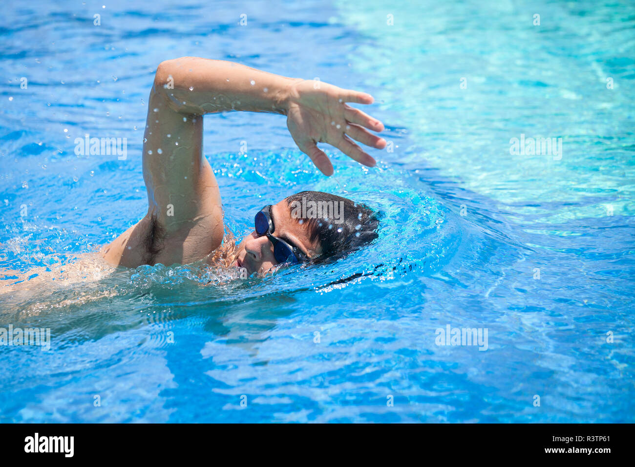 Young man swimming the front crawl in a pool Stock Photo - Alamy